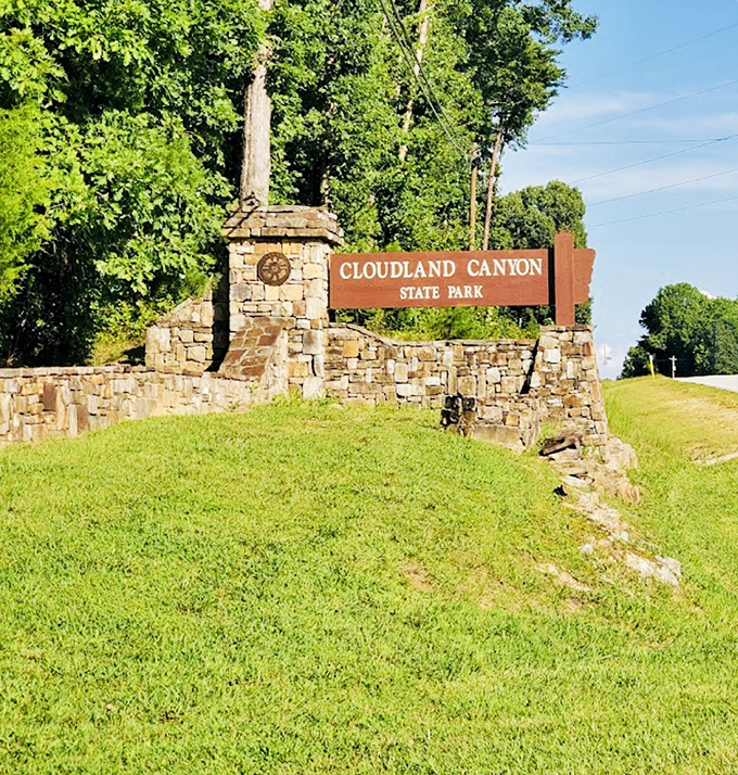 The entrance sign, built to last like the memories you'll make here. Stone and wood announce: "Prepare to be impressed, but also, please stay on the trails."