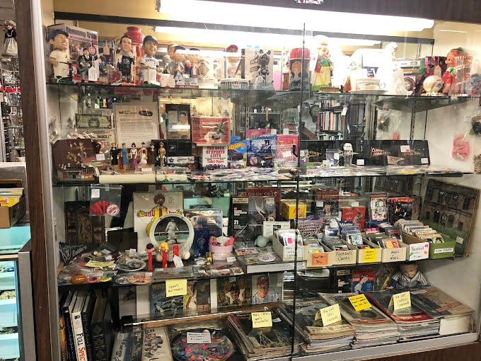 Sports cards, collectible figurines, and memorabilia create a shrine to nostalgia where childhood heroes and forgotten franchises live forever.