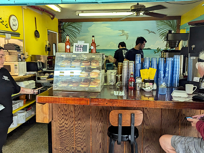 Behind the counter, where breakfast magic happens &ndash; complete with a beach mural that reminds you exactly where you are in this delicious world.