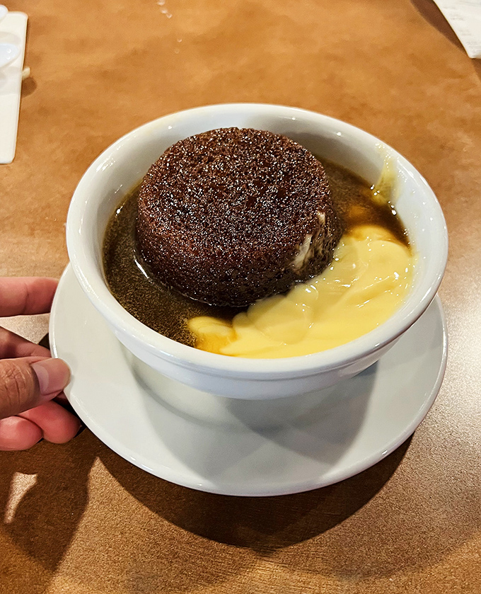 Sticky toffee pudding swimming in custard &ndash; because every great British meal deserves a proper sweet ending.