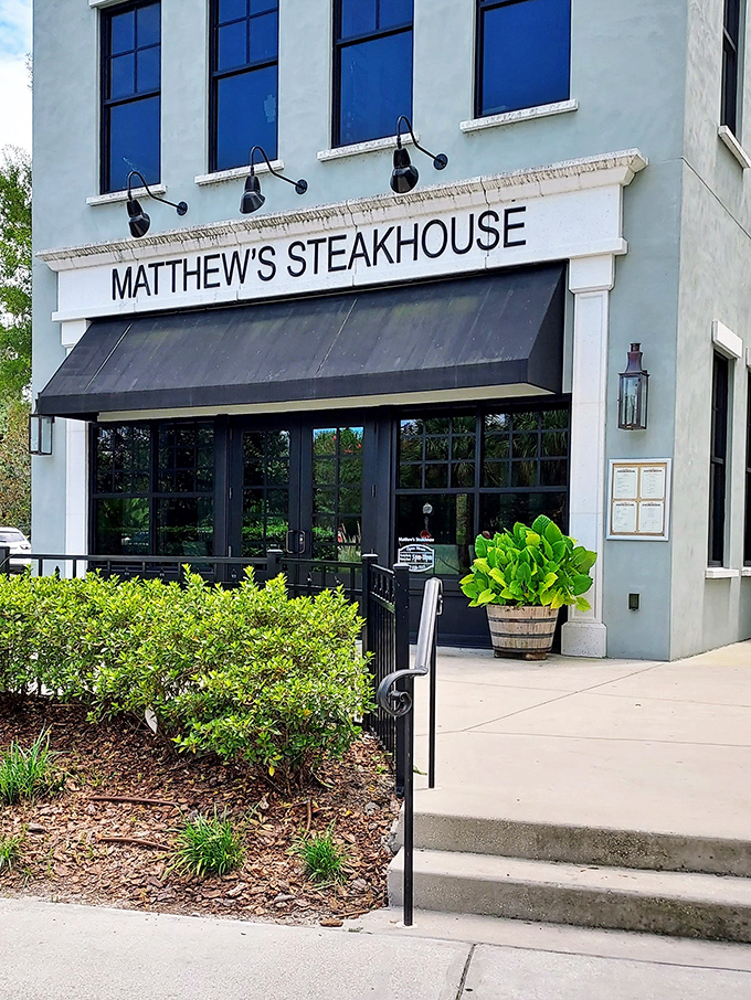 The entrance that launches a thousand cravings. That black awning isn't just shade—it's the curtain before a spectacular culinary show in Winter Garden's dining scene.