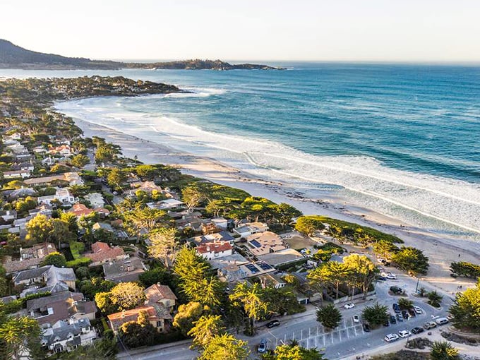 Aerial views reveal how this coastal gem nestles perfectly between forest, beach, and rolling hills.