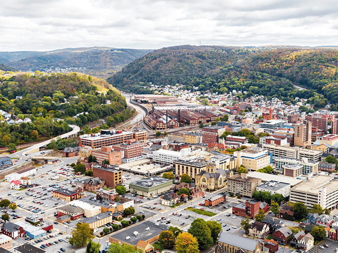 Aerial views reveal Johnstown's perfect nestling between protective mountains. This natural amphitheater creates both stunning vistas and remarkably affordable living.