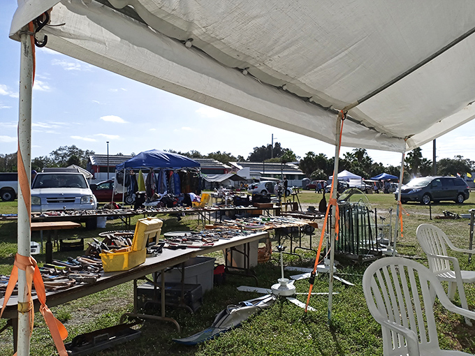 Tools of every trade spread across makeshift tables. Under that white canopy, someone's DIY dreams await at prices that would make hardware stores blush.