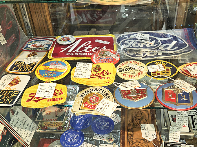 Patches of Michigan pride and automotive history under glass. Each emblem tells a story of brand loyalty stronger than any modern app subscription.