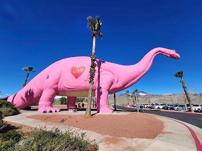 Dinny the pink dinosaur stands proudly in the desert sun, sporting a heart on her side. Prehistoric kitsch at its finest!