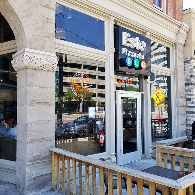 Este Pizzeria's charming storefront invites you in with its nostalgic brick facade and wooden patio. Pizza paradise hiding in plain sight!