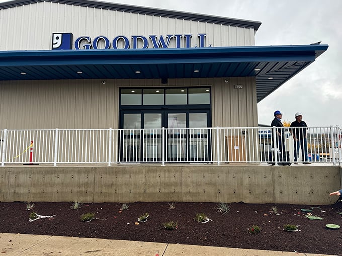 The gleaming blue Goodwill sign promises treasure hunting adventures within this warehouse wonderland of possibilities.