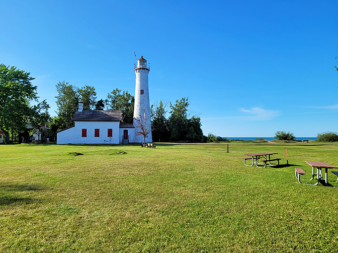 The historic lighthouse at Harrisville State Park stands tall against the blue Michigan sky, a postcard-perfect scene waiting for your camera.