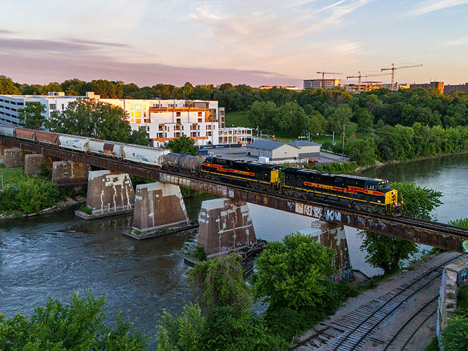 A train rumbles over the Iowa River in Iowa City, where affordable living meets college-town charm. Retirement dollars stretch further with these scenic views!