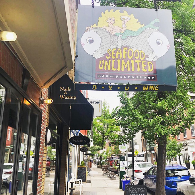 The whimsical mermaid-riding-a-fish sign promises seafood adventures in the heart of Philly. Peace, love, and lobster indeed!