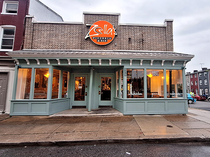 Zella's mint-green storefront glows like a beacon of pizza hope on this Baltimore corner. That orange sign promises cheesy delights within!