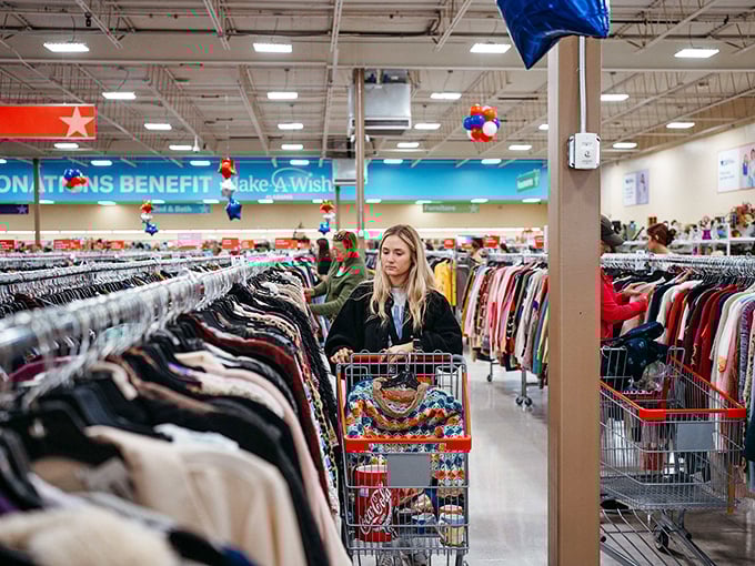 Thrift paradise in action! Shoppers navigate endless aisles of clothing where yesterday's fashion becomes tomorrow's statement piece.