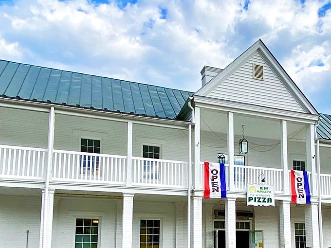 Southern hospitality meets pizza perfection at this unassuming roadside gem with its welcoming porch and "OPEN" flag.