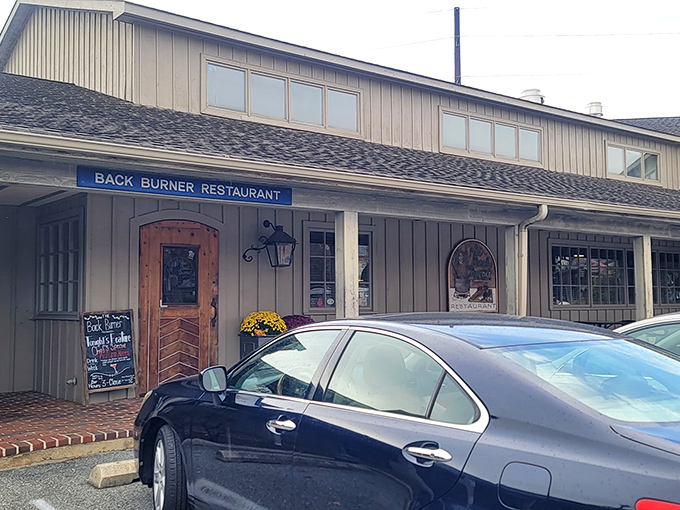 That iconic blue sign beckons hungry travelers – the Back Burner's cozy exterior hides a wonderland of flavor inside.