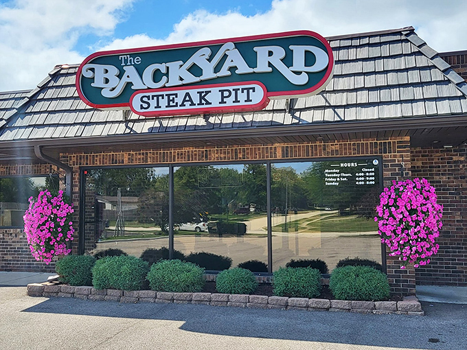 The Backyard's welcoming exterior promises neighborhood charm with serious steak credentials inside those glass doors.