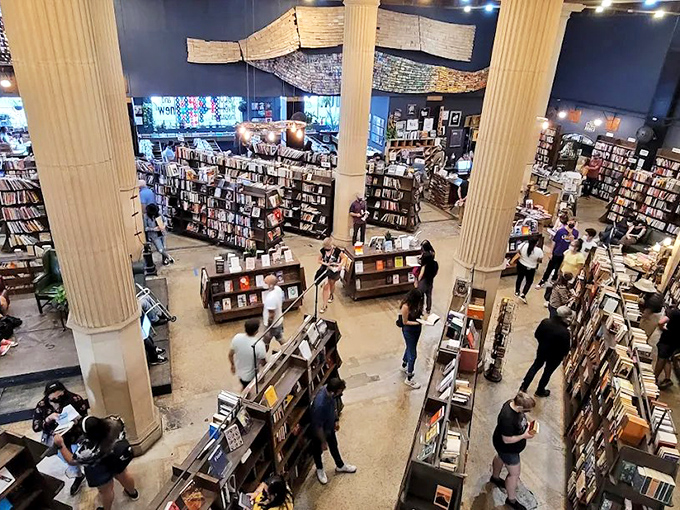 Book lovers navigate a labyrinth of literary treasures under the watchful gaze of those magnificent bank vault columns.