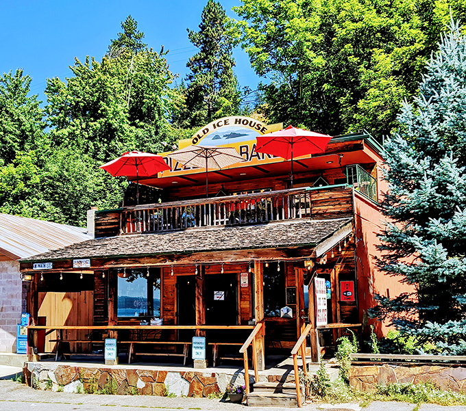 Fall colors frame this hidden gem like nature's own Instagram filter. Those red umbrellas practically whisper "sit here with a slice!"