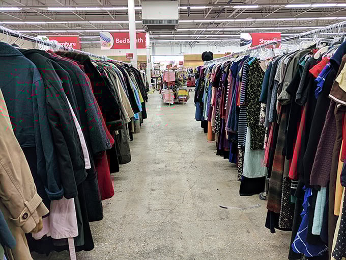 Color-coordinated clothing racks create a rainbow of second-hand dreams where every hanger holds potential magic.