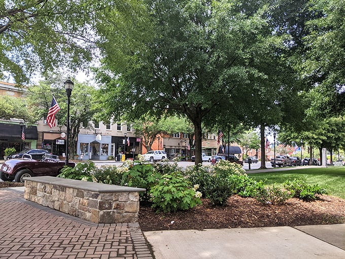 Take a seat on this stone bench and enjoy the lush greenery and flags lining a quintessential, friendly American street.