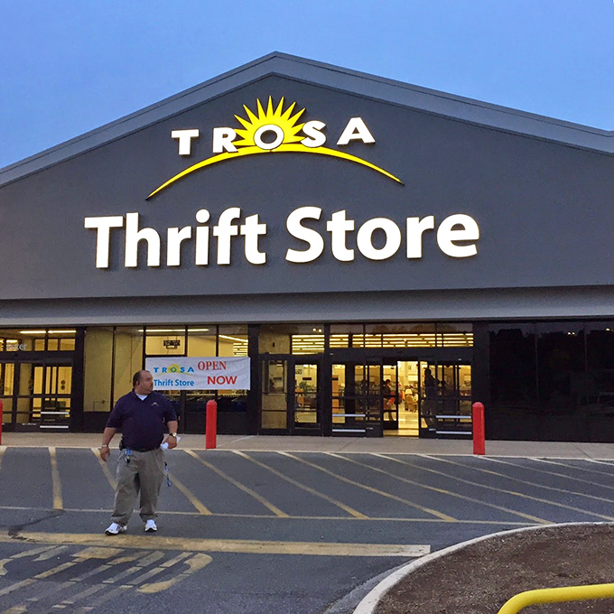 As dusk settles, the illuminated TROSA sign beckons bargain hunters like a lighthouse guiding ships to safe harbor filled with second-hand treasures.