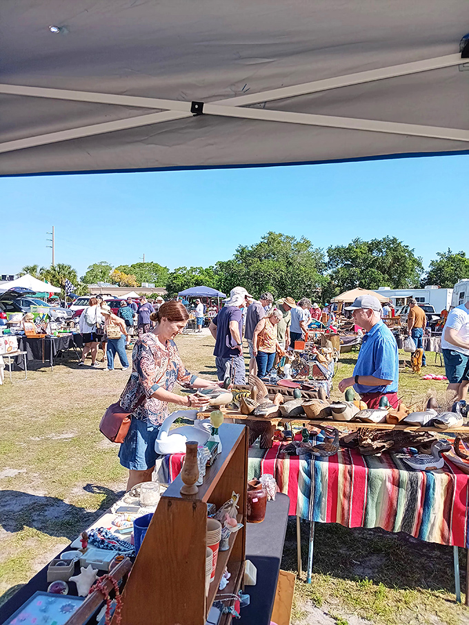 Bargain archaeology in action! Shoppers examine artifacts of everyday life under white canopies while vendors stand ready to share the stories behind their wares.