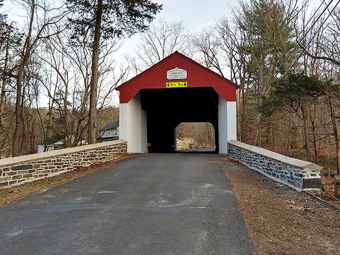 Approaching the bridge entrance feels like discovering a secret passage. The stone abutments and weathered sign hint at stories spanning generations.