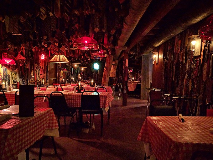Step inside and you've entered tie purgatory. Hundreds of neckties dangle from the ceiling like trophies, illuminated by the warm glow of vintage lamps and checkered tablecloths.