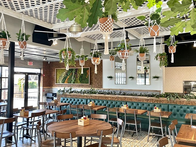 Hanging plants create a botanical canopy above teal banquettes and wooden tables&mdash;the perfect backdrop for both Instagram and actual human conversation.