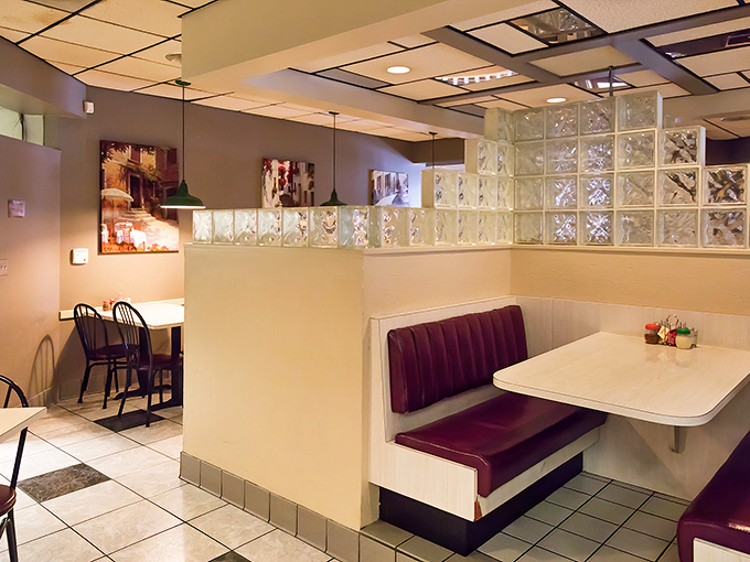 Classic glass block dividers and burgundy vinyl booths create time-travel dining where conversations flow as easily as the marinara sauce.