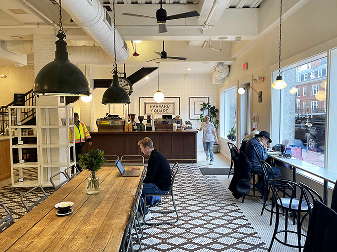 Inside, industrial chic meets cozy comfort. The communal wooden tables invite both scholarly discussions and intimate coffee dates beneath those statement pendant lights.