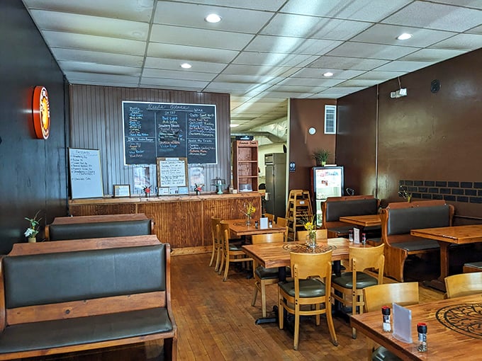 Wooden booths, simple tables, and a chalkboard menu create that perfect "neighborhood joint" atmosphere where food trumps flash every time.