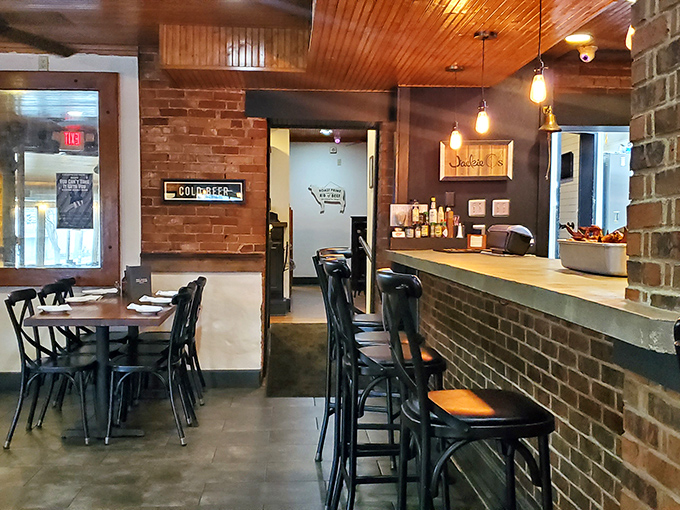 Industrial meets cozy in this thoughtfully designed interior where exposed brick, wooden ceilings, and pendant lighting create the perfect backdrop for BBQ bliss.
