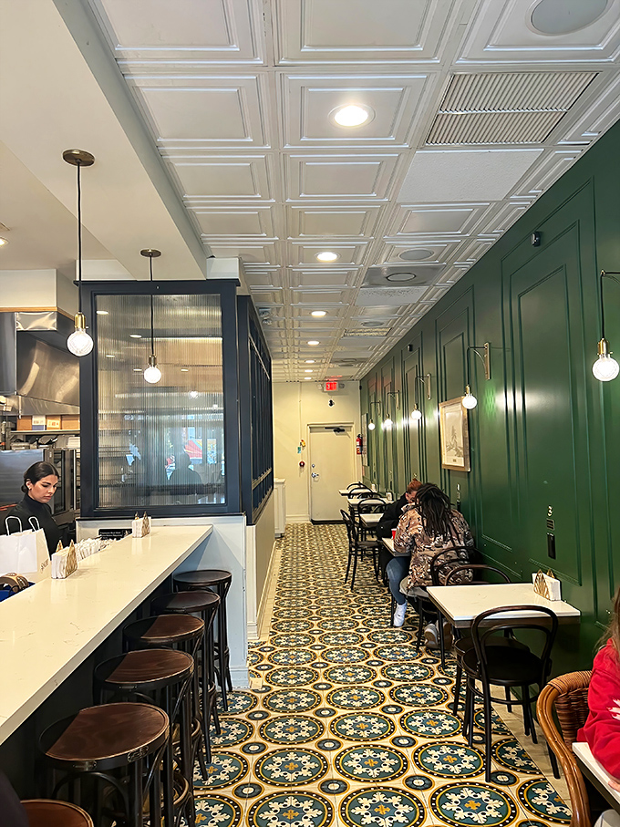 Emerald green walls, patterned tiles, and elegant lighting create the perfect backdrop for sandwich artistry. Like dining in a stylish abuela's kitchen.
