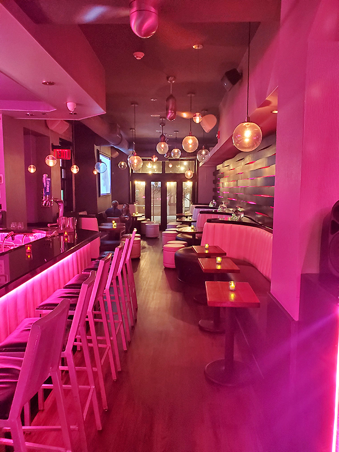 Step inside and you're bathed in a dreamy pink glow that makes everyone look like they're starring in their own music video. The pendant lights add just the right touch of drama.