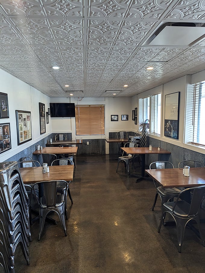 Industrial chic meets homestyle comfort with those ornate tin ceiling tiles and metal chairs that somehow feel more welcoming than your favorite recliner.