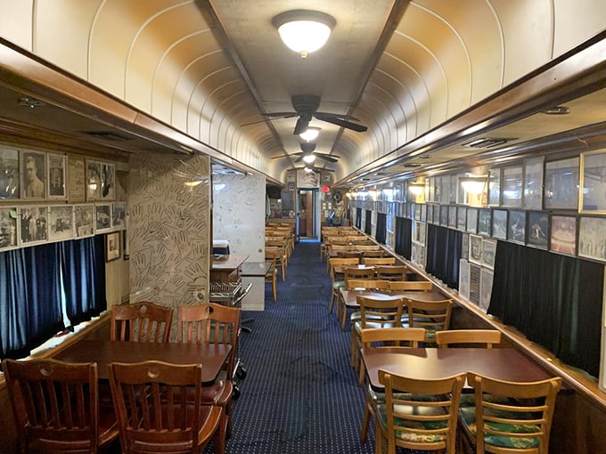All aboard for flavor! The narrow dining aisle stretches toward culinary adventure, with wooden tables flanking both sides beneath the iconic curved ceiling.