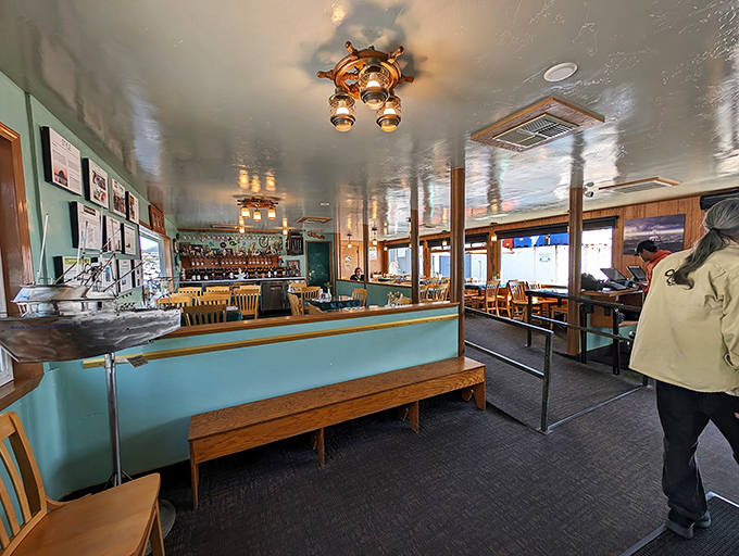 Nautical charm meets cozy comfort in this dining room where ship wheels and wooden beams aren't decorative choices&mdash;they're practically family heirlooms.