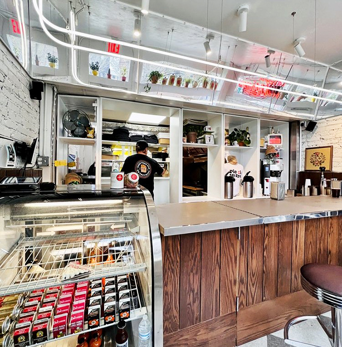 Behind this wooden counter, breakfast dreams come true. The white-painted brick and hanging plants create a space that's both nostalgic and Instagram-ready.
