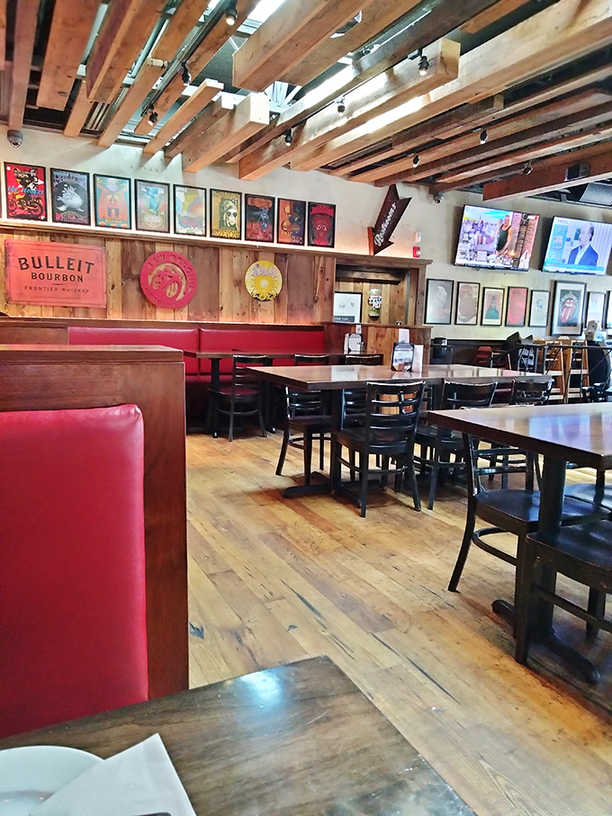 Exposed wooden beams, concert posters, and those signature red booths create the perfect backdrop for the food drama about to unfold on your plate.