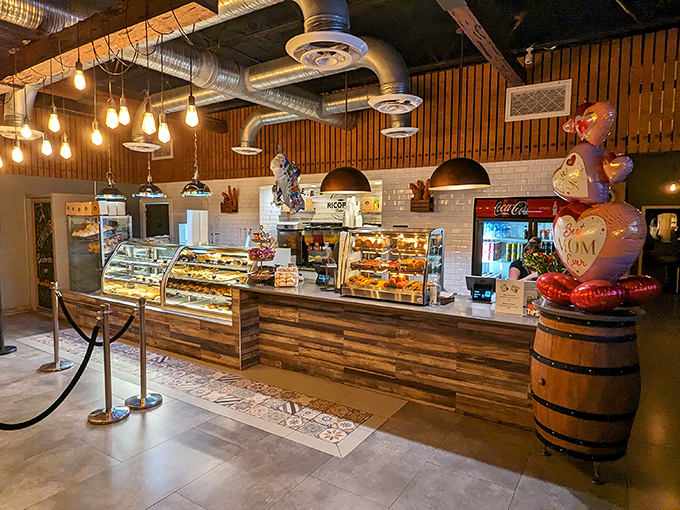 Edison bulbs cast a warm glow over wooden accents and subway tile, creating an atmosphere where industrial chic meets comfort &ndash; like your coolest friend's kitchen, but with better pastries.