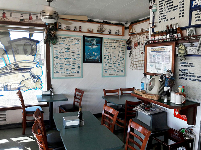 Nautical charts and fishing memorabilia transform this small dining area into a captain's quarters where seafood dreams are served on paper, not porcelain.