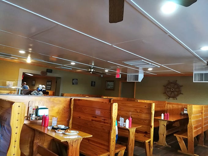 Nautical charm meets down-home comfort in these wooden booths. The ship's wheel on the wall isn't just decoration&mdash;it's steering you toward flavor paradise.