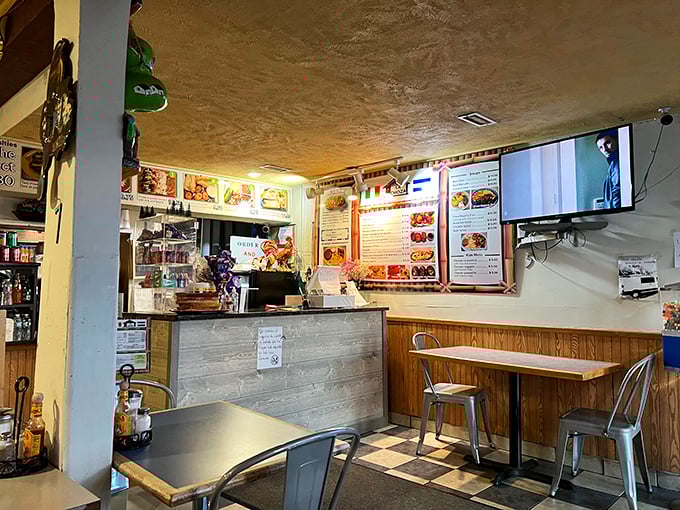 Inside, simplicity reigns supreme. Metal chairs, wooden tables, and a menu board that promises authentic delights without the frills or unnecessary adjectives.