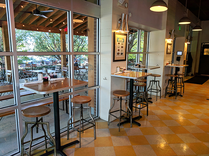 Honey-toned checkerboard floors and industrial-chic seating create that perfect sweet spot between "trendy enough for Instagram" and "comfortable enough for your hangover."