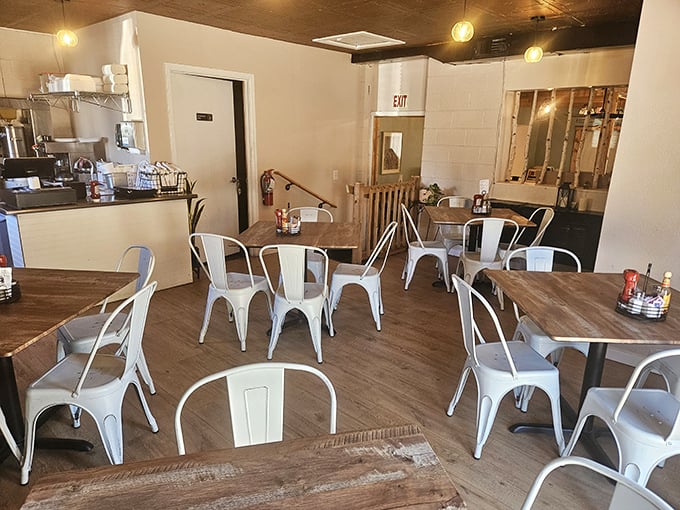 Modern rustic charm defines the interior, where wooden tables meet metal chairs in a space that feels both contemporary and comfortably familiar.