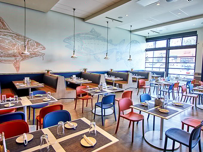 Inside, the nautical-themed dining room balances modern design with maritime charm. Fish illustrations swim across the walls while colorful chairs add a playful pop.