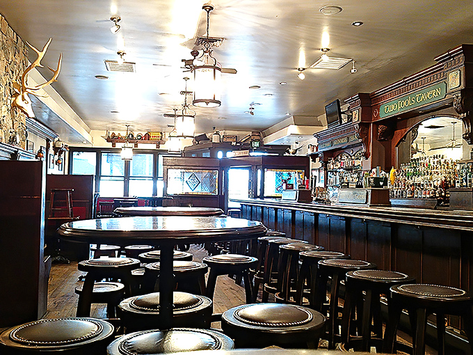 Dark wood, pendant lighting, and leather-topped stools create that unmistakable pub atmosphere where conversations flow as smoothly as the beer.