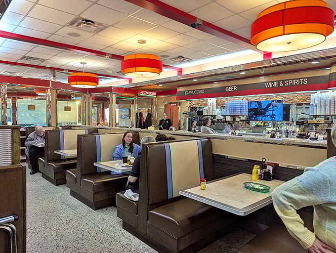 Classic diner booths invite you to slide in and stay awhile, where orange pendant lights cast that perfect "everyone looks good here" glow.