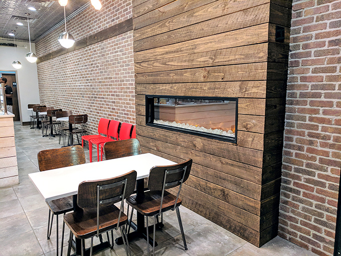 Exposed brick walls meet modern wooden accents in this thoughtfully designed space. That fireplace feature? Pure genius for a frozen custard shop in Georgia.
